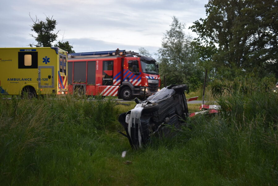 Auto op zijkant na crash, bestuurder gewond in Aduard